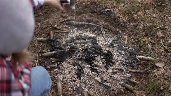 High Angle View Bonfire Ash with Caucasian Young Woman Pouring Water in ...