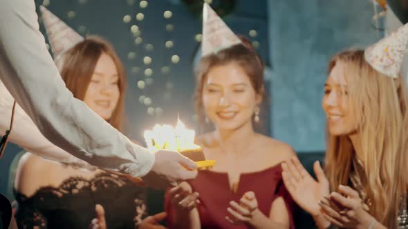 Young Woman Blowing Out Fire on Candles and Making Wish at Party or ...