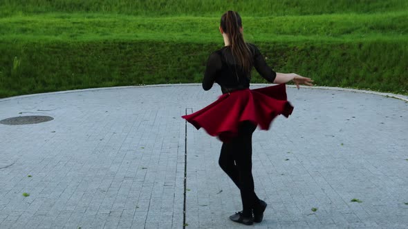 Full body from the back view at female dancer dancing in the park ...