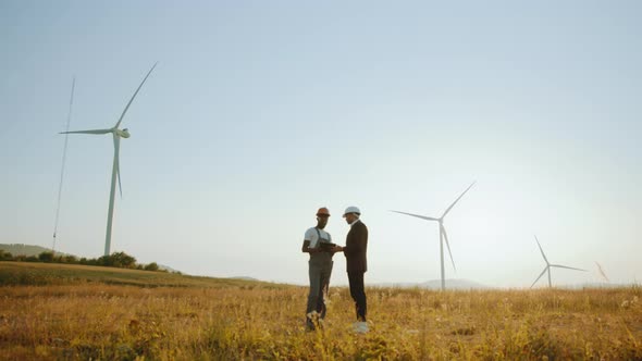Engineer and Inspector Working Together on Windmill Farm, Stock Footage