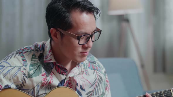 Close Up Of Asian Man Composer With Notebook On Table Playing Guitar At ...