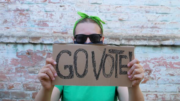 Woman shows cardboard Go Vote sign Voting balloting polling Political ...