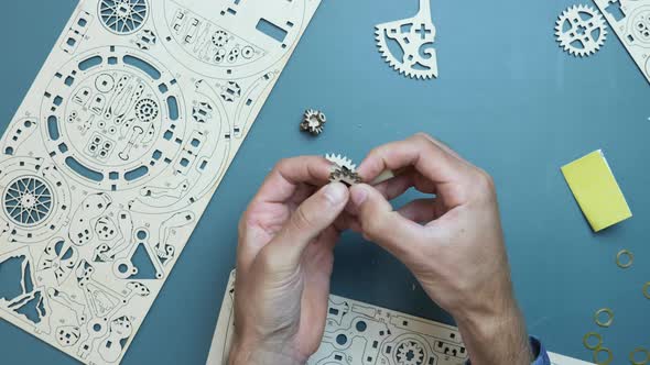 Man holding small flywheel details in hands, assembling mechanical ...