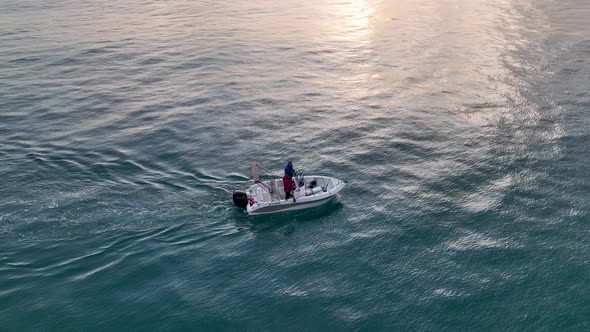 Fishing boat far out to sea at sunset, Stock Footage | VideoHive