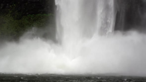 Static close up shot of a waterfall crashing down into a body of water ...