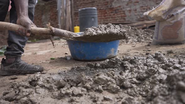 Constructing a traditional house in Africa. African worker Man picking ...