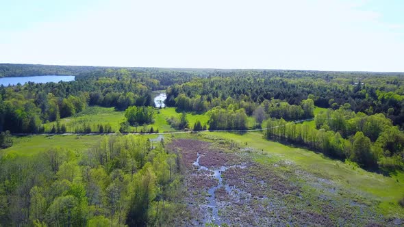 UHD Aerial overhead shot of a swamp then a pan towards a nearby lake ...