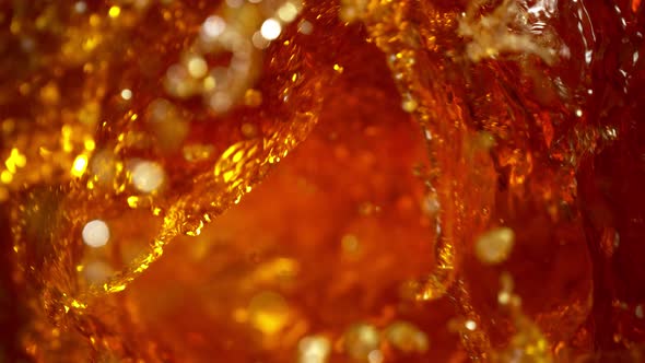 Super Slow Motion Shot of Falling Ice Cubes Into Golden Liquid Vortex ...