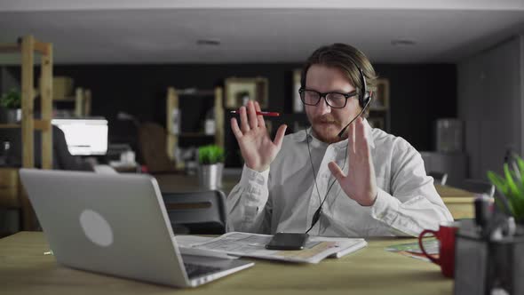 Manager in Headphones Is Working on Laptop at the Office, Stock Footage