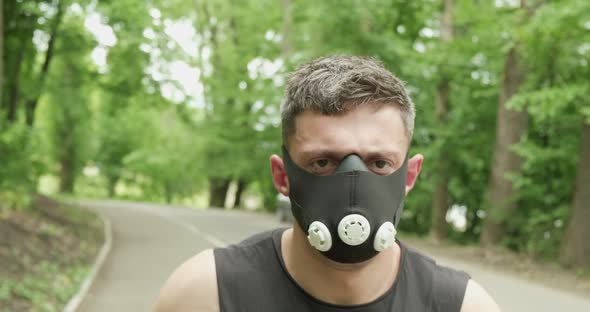 Young Male with Face Mask in Sportswear Running on the Road at Forest ...