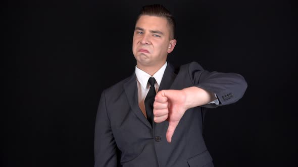 Young Businessman Shows Dislike on Hand. Man in a Black Suit on a Black ...