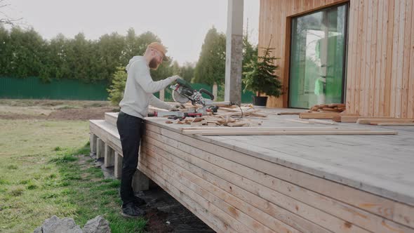 Man Cutting Wood Using Table Saw on Construction Site of a Modern ...