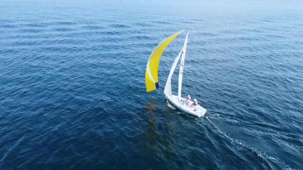 Sea regatta. A beautiful white yacht with a yellow sail sails in the ...
