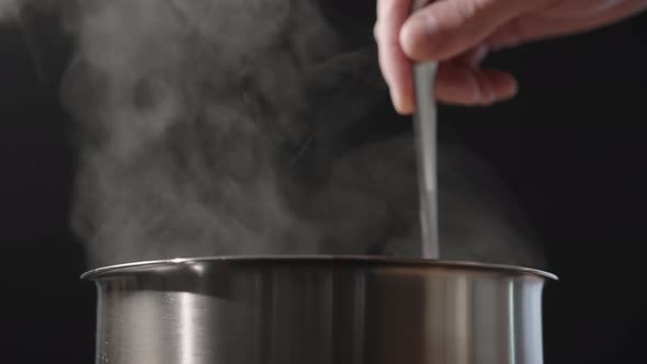 Slow Motion Man Hand Stiring with Fork in Pot with Rising Steam, Stock ...