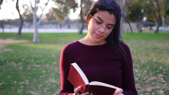 A female college student reading and studying a textbook before ...