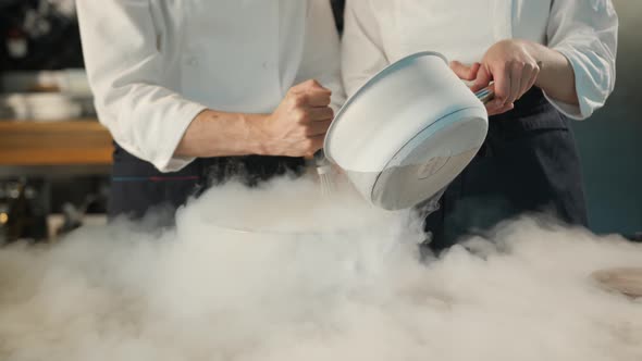Close-up of a professional kitchen: liquid nitrogen is added during the ...