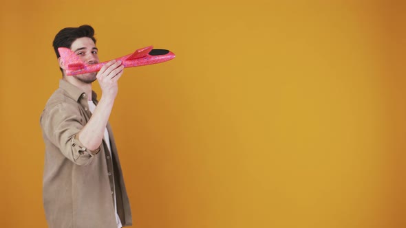 Young Fellow is Smiling Playing with Pink Flying Toy Airplane While ...