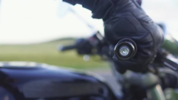 Close-up of the motorcyclist's hand twisting throttle handle of bike ...