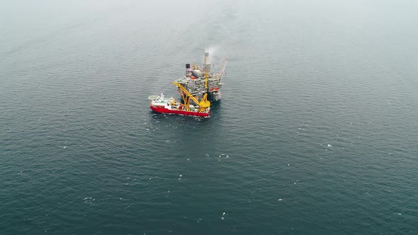 Top view of an offshore oil platform with a support vessel next to it ...