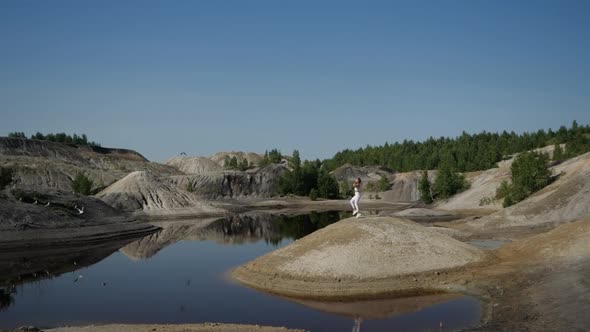 Shooting From Afar a Girl Athlete in White Sports Uniform Performs ...