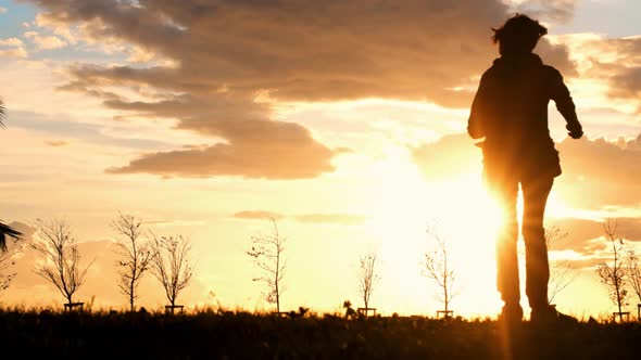 Slow motion of a thin woman silhouette running towards the sun at ...