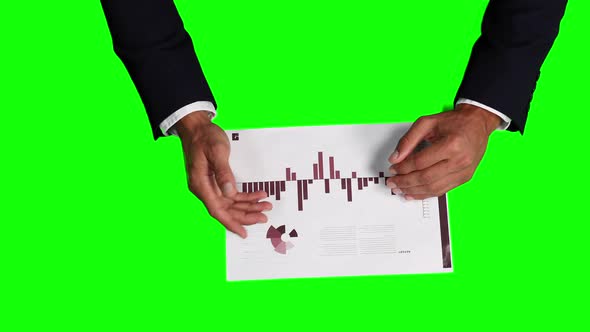 Overhead view of a Caucasian man explaining graphs with green screen ...