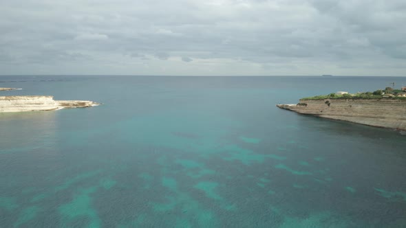 AERIAL: Ta Kalanka Sea Cave Bay with Cloudy Sky and Beautiful Turquoise ...