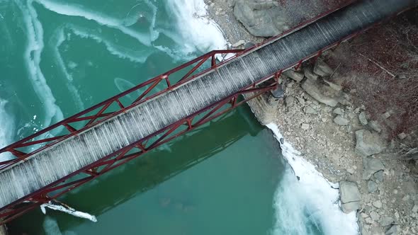 Rusty Footbridge over Icy Mountain River - Top/Drop Drone Shot, Stock ...