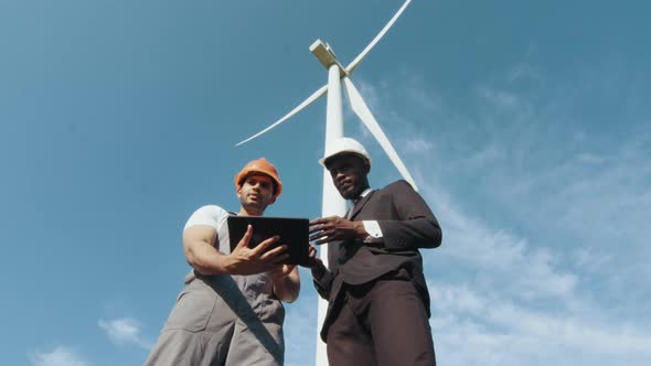 Engineer and Inspector Working Together on Windmill Farm, Stock Footage