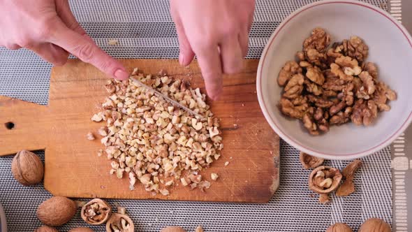 Chopping Walnuts Cores with Kitchen Knife on a Wood Cutting Board ...