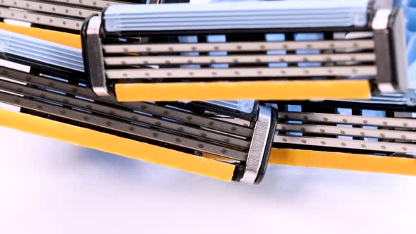 Close up view of some disposable shaver razor blades rotating on white ...