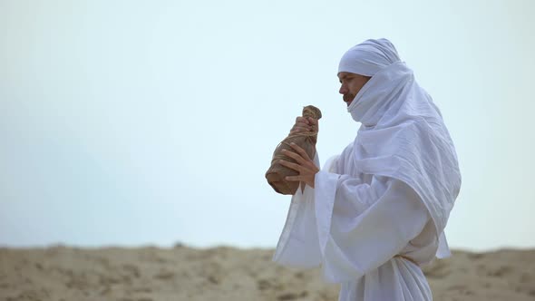 Thirsty Arab Pilgrim Drinking Water From Bottle in Desert, Drought ...