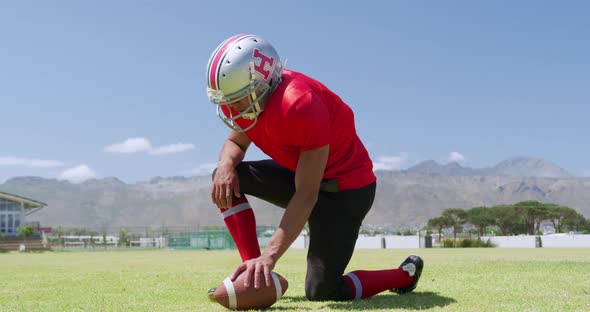 American football player kneeling with ball, Stock Footage | VideoHive