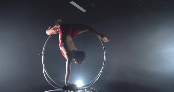 Brunette Woman is Doing an Upside Down Split in a Hoop Gymnastics ...