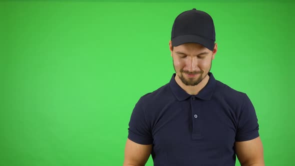 A Young Handsome Mailman Offers a Package To the Camera with a Smile ...