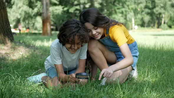 Children explore the world around them. The boy is holding a magnifying ...
