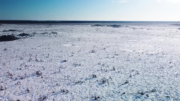 Aerial birdseye view of snowy bog landscape with hiking trail and ...
