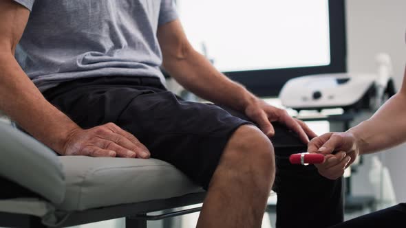 Close up of doctor's checking knee of percussion hammer. Shot with RED ...