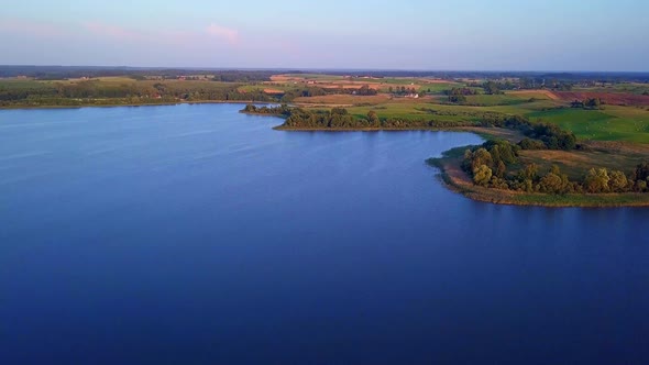 Aerial shot of a secluded lake, surrounded by fields and farms ...