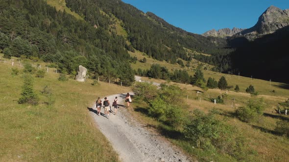 Aerial drone shot of teen friends walking through a mountain path ...