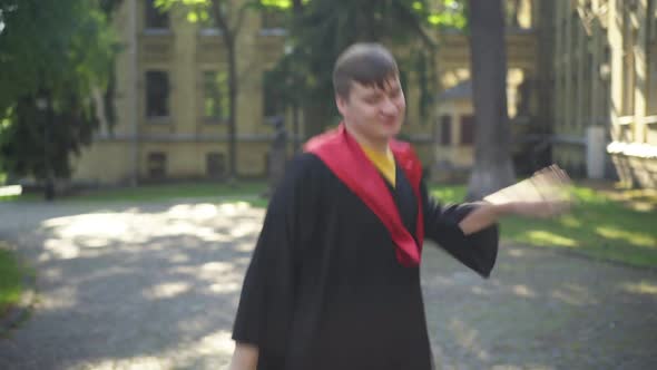 Portrait of Excited Young Man in Graduation Toga Dancing in Sunshine at ...