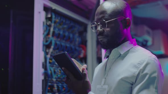 African American IT Engineer Working on Tablet in Data Center, Stock ...