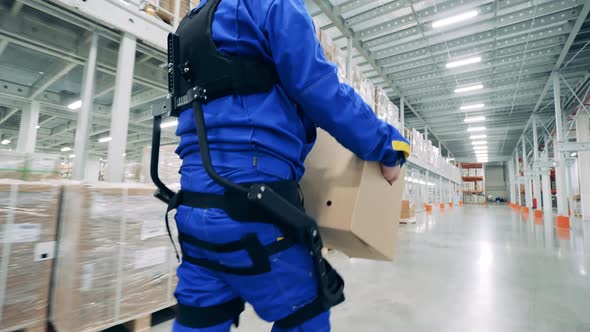 Warehouse Worker is Wearing Ergoskeleton at Work, Stock Footage | VideoHive