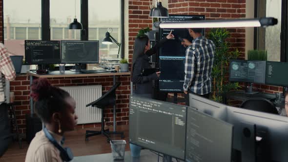 System Developers Analyzing Code on Wall Screen Tv Looking for Errors ...