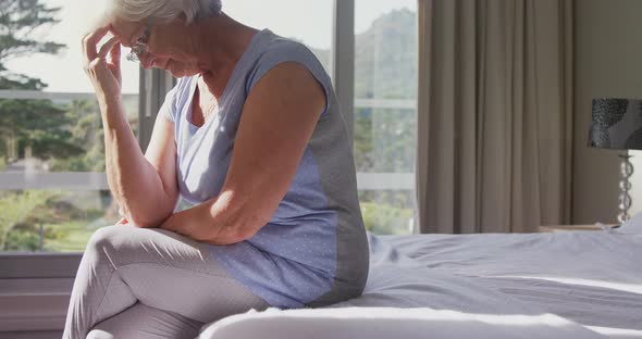 Worried senior woman feeling bad seating on bed 4K 4k, Stock Footage