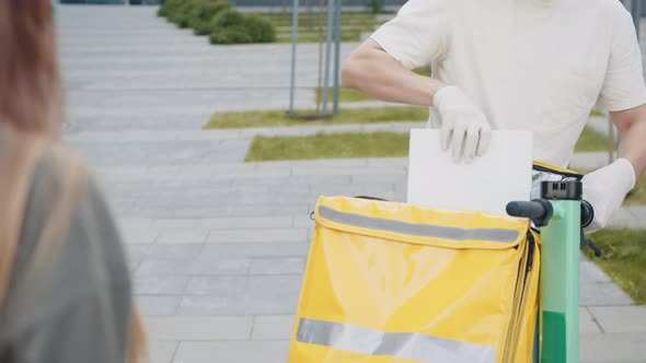 An Young Mailman Courier with a Protective Mask and Gloves is ...