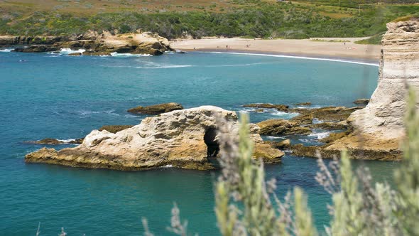 seacliff reveal overlooking ocean rocks with beach in back, Stock Footage