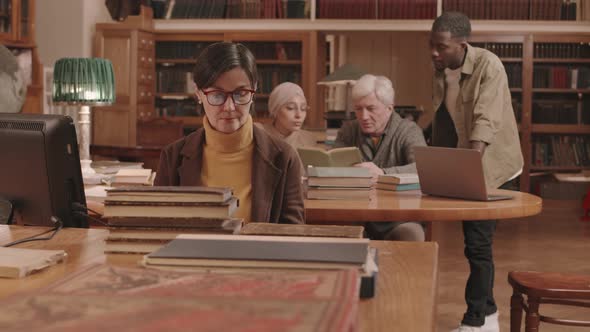 Female Librarian Sorting Books in Library, Stock Footage | VideoHive