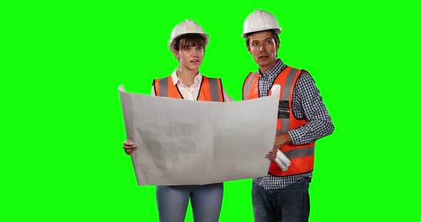 Front view of site workers looking at site map with green screen ...