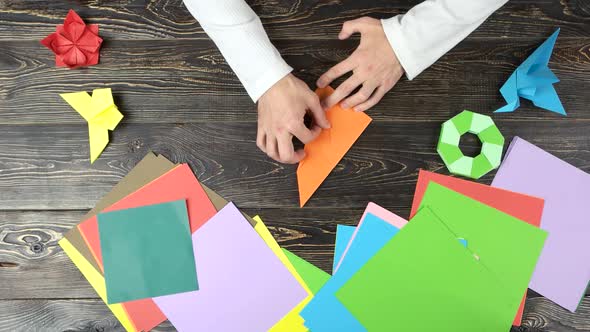 Man Folds Paper Sheets While Doing Origami., Stock Footage | VideoHive